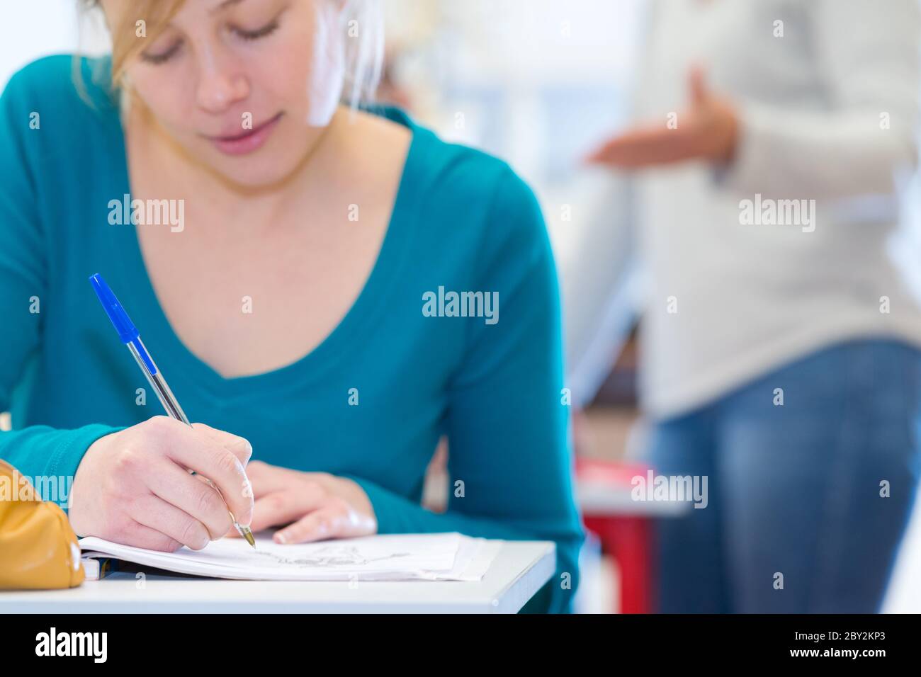 young female student writing notes during college lecture Stock Photo ...