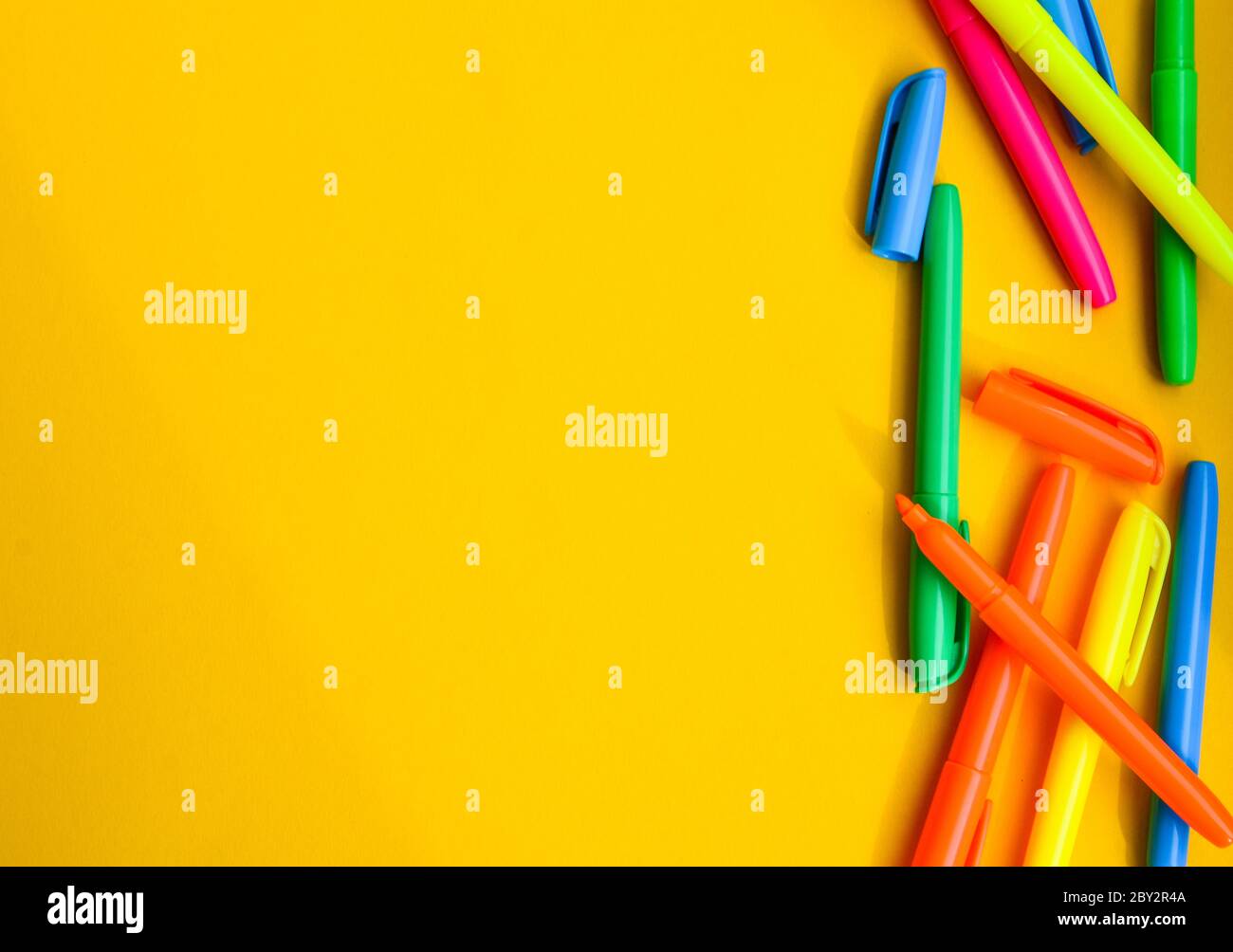 Felt-tip pens on a yellow background with copy space, set of new bright ...