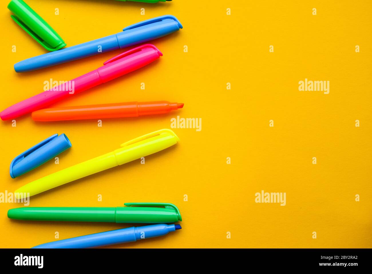 Felt-tip pens on a yellow background with copy space, set of new bright ...