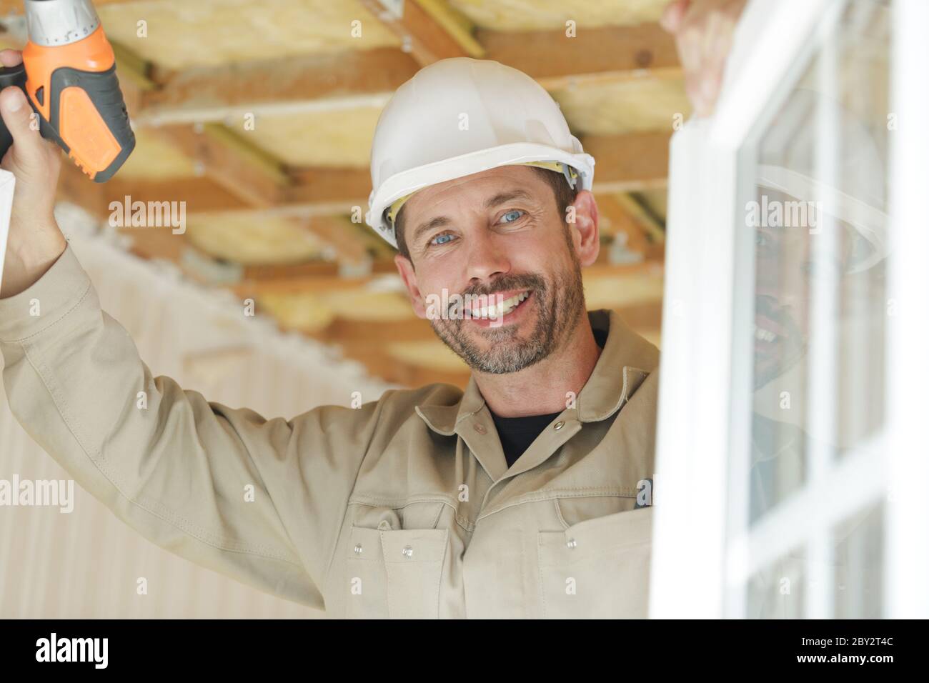 service man installing window with screwdriver Stock Photo - Alamy