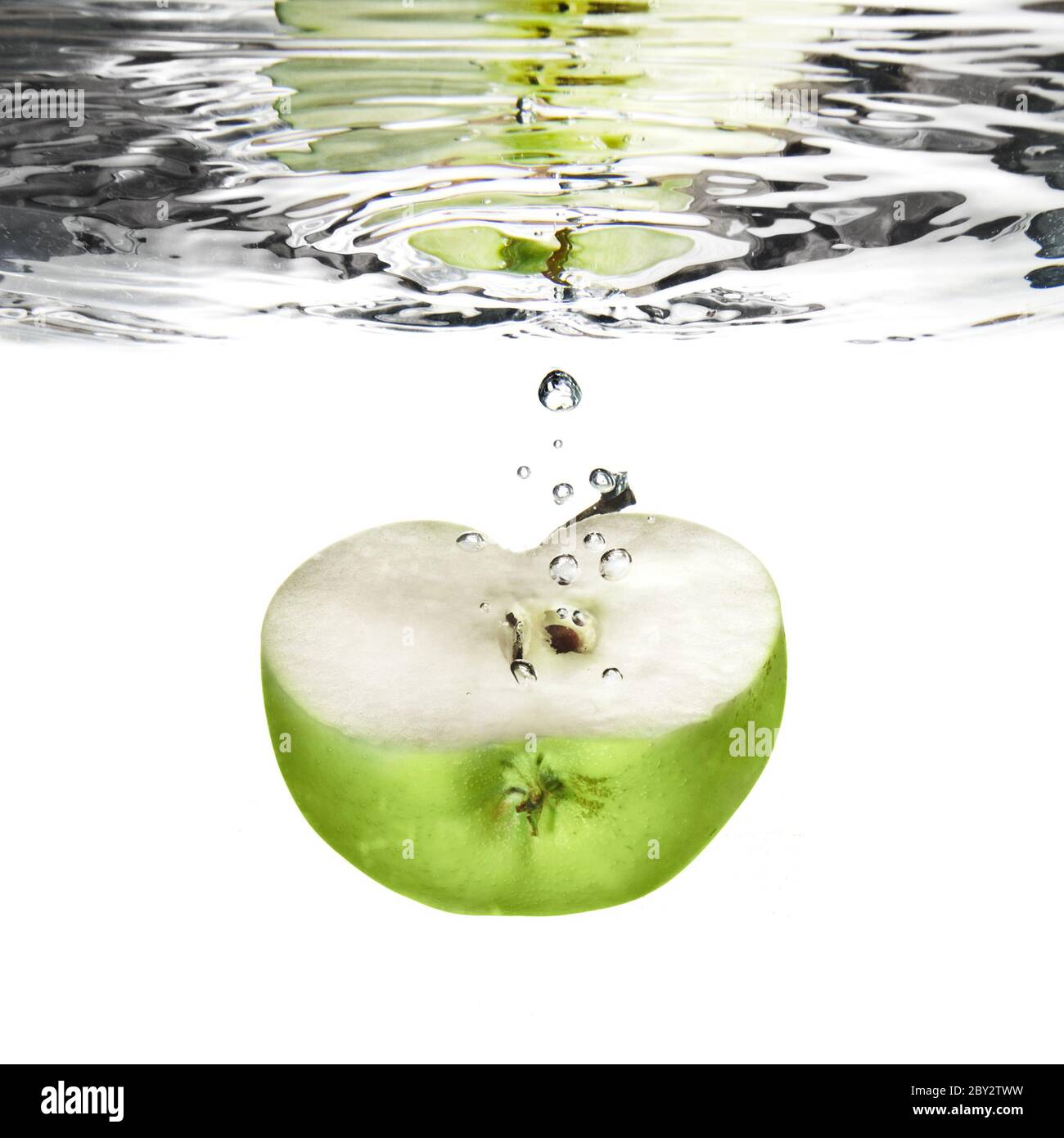 green apple dropped into water with bubbles isolated on white Stock ...