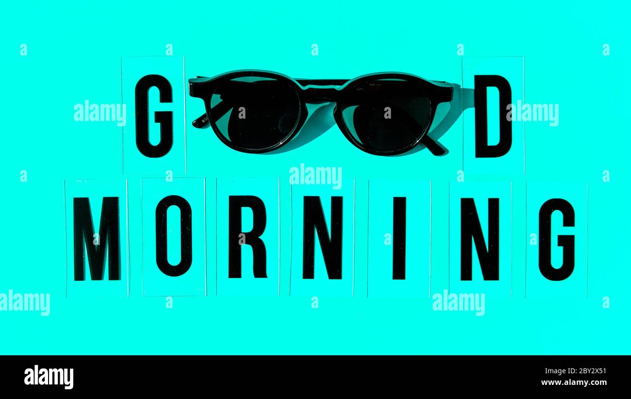 Sunglasses on Purple blue background and text GOOD MORNING. Top view ...
