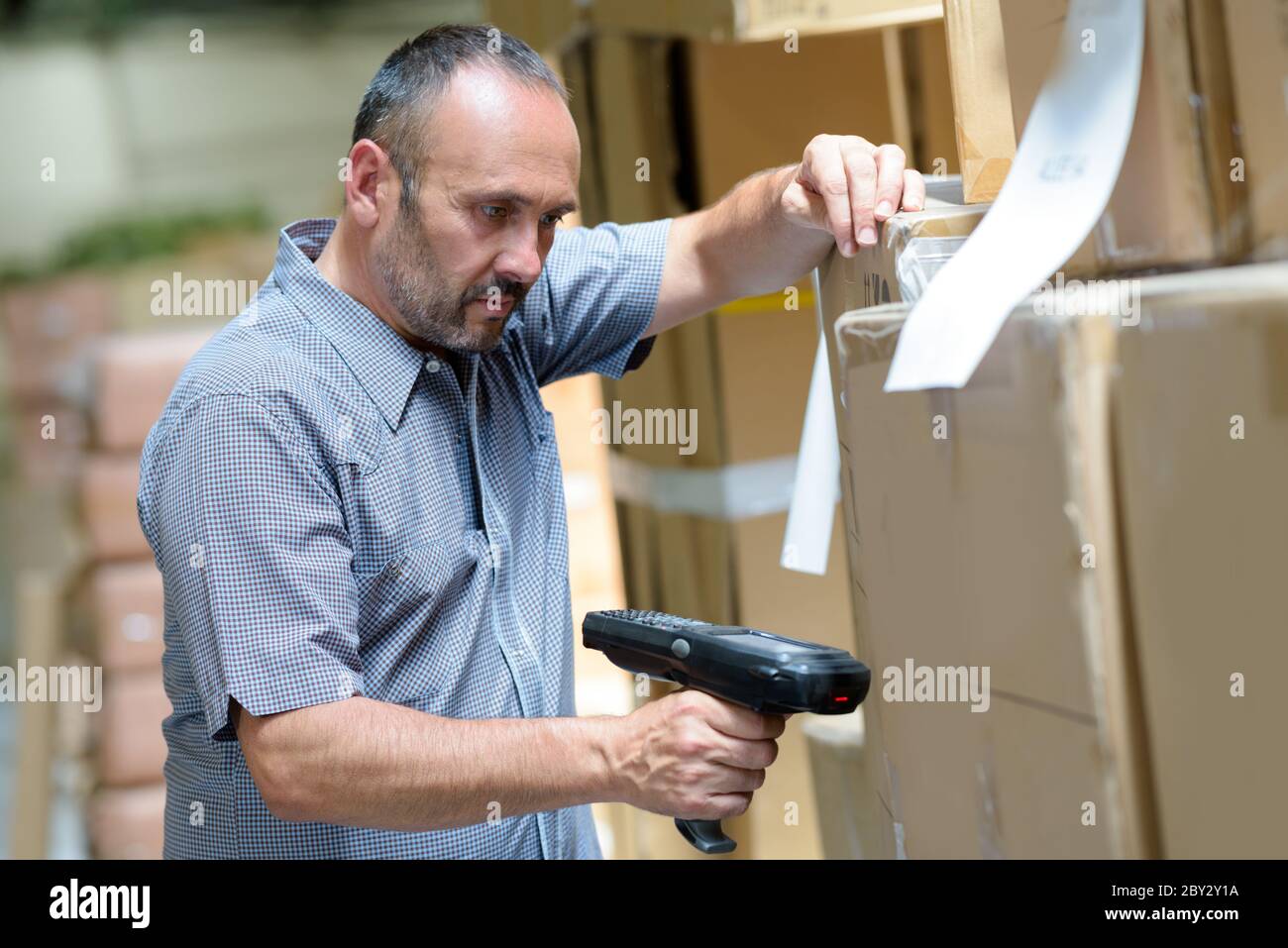 postman worker scanning package with barcode scanner Stock Photo - Alamy