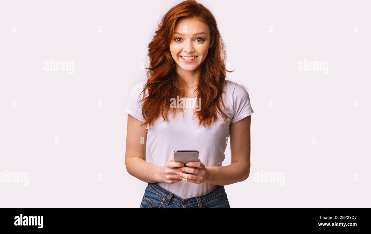 Happy Millennial Girl Using Smartphone Standing Over White Studio ...