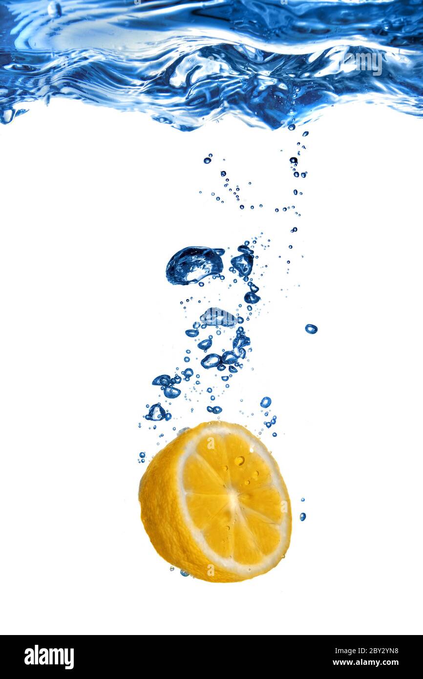 Fresh lemon dropped into water with bubbles isolated on white Stock ...