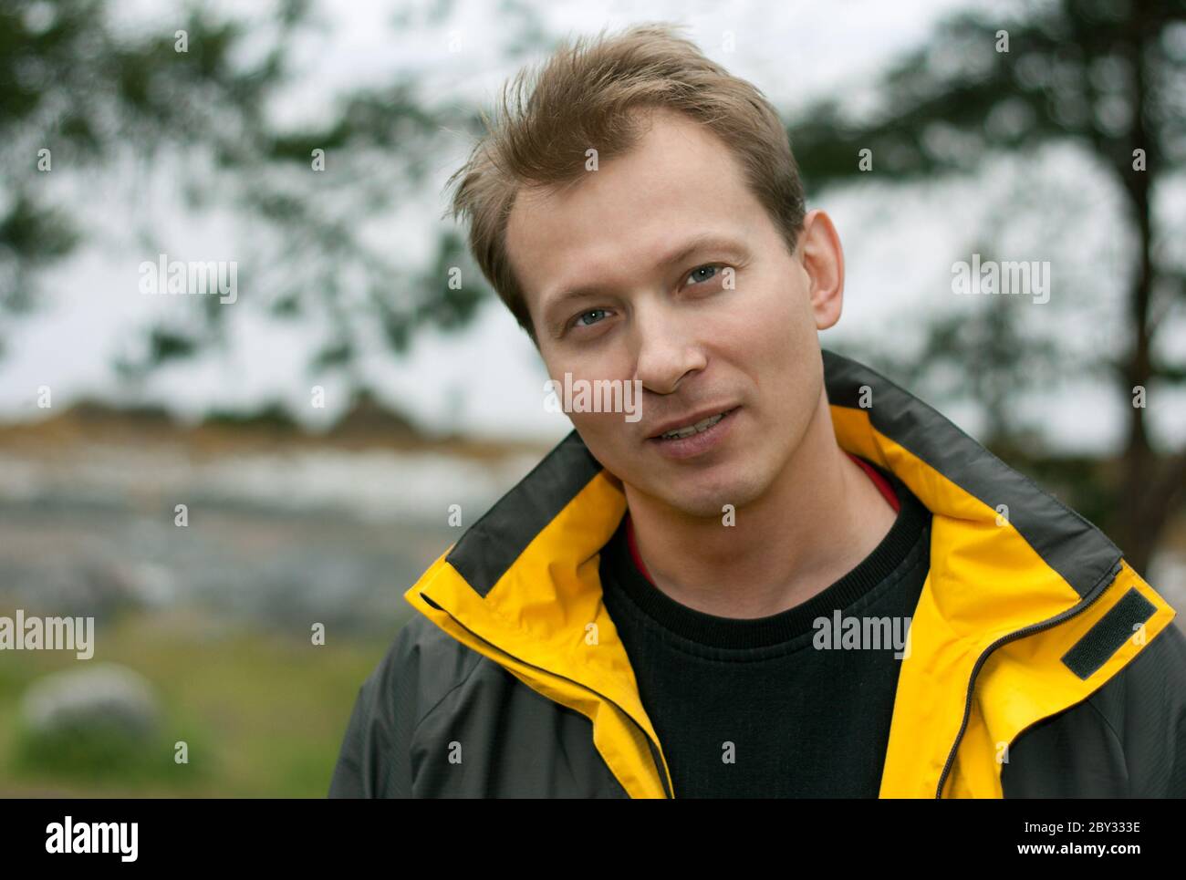 Man in yellow jacket smiles Stock Photo - Alamy
