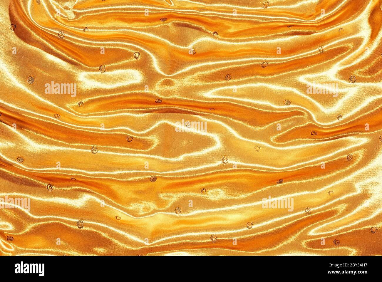 Golden textile with folds as background Stock Photo - Alamy