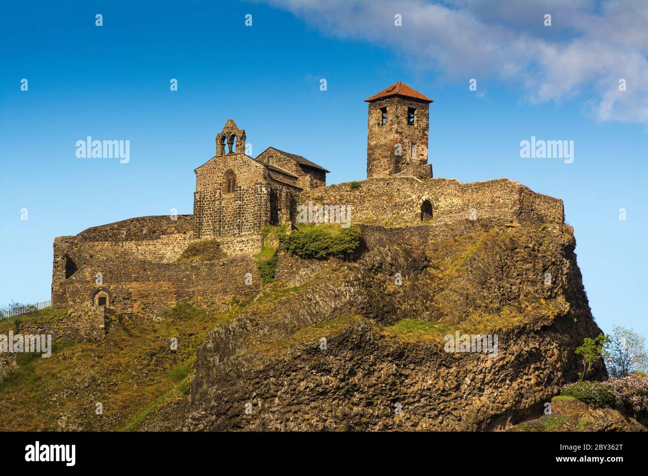 Saint-Ilpize castle perched on a volcanic peak above river Allier ...
