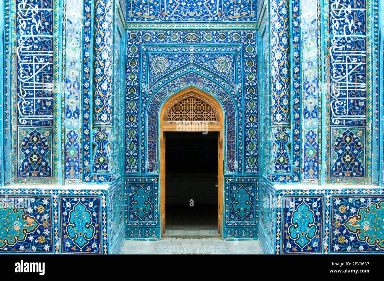 Decorative muslim mosaic tiles at the arched entrance with open door of ...