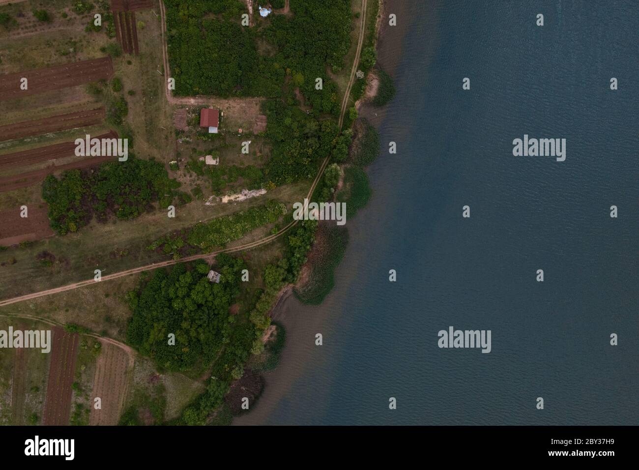 Aerial view of agricultural lands on the coast of river with green ...