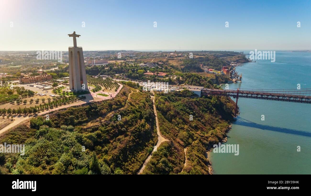 Aerial bridge on April 25th, across the Tejo River, statue of Jesus ...