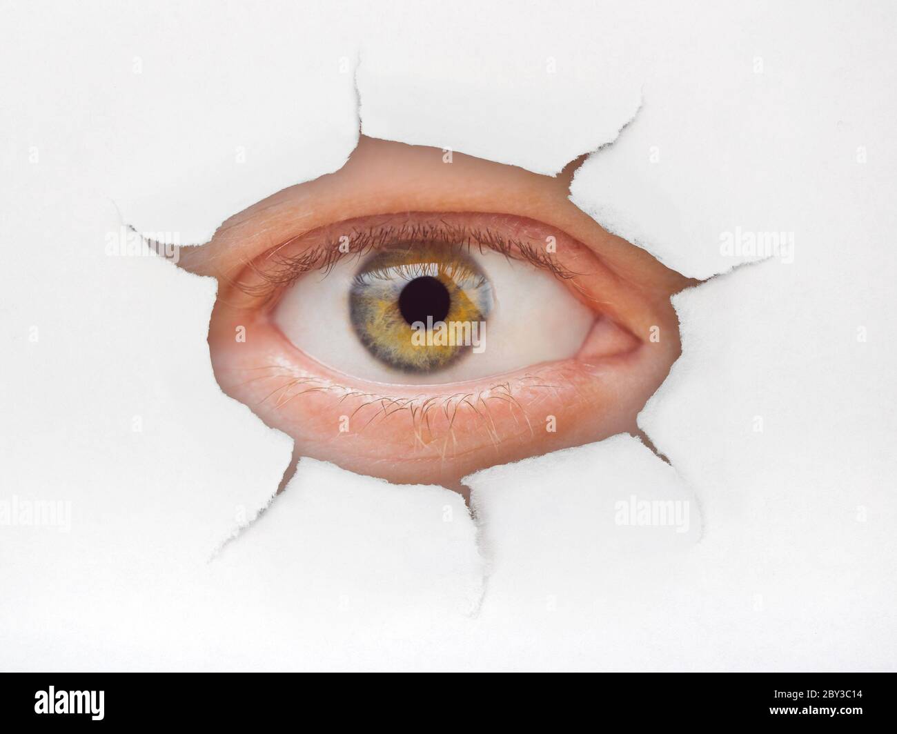 Eye looking through hole on paper Stock Photo - Alamy