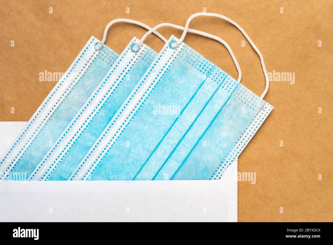 Blue medical surgical face mask in white postal envelope on yellow ...