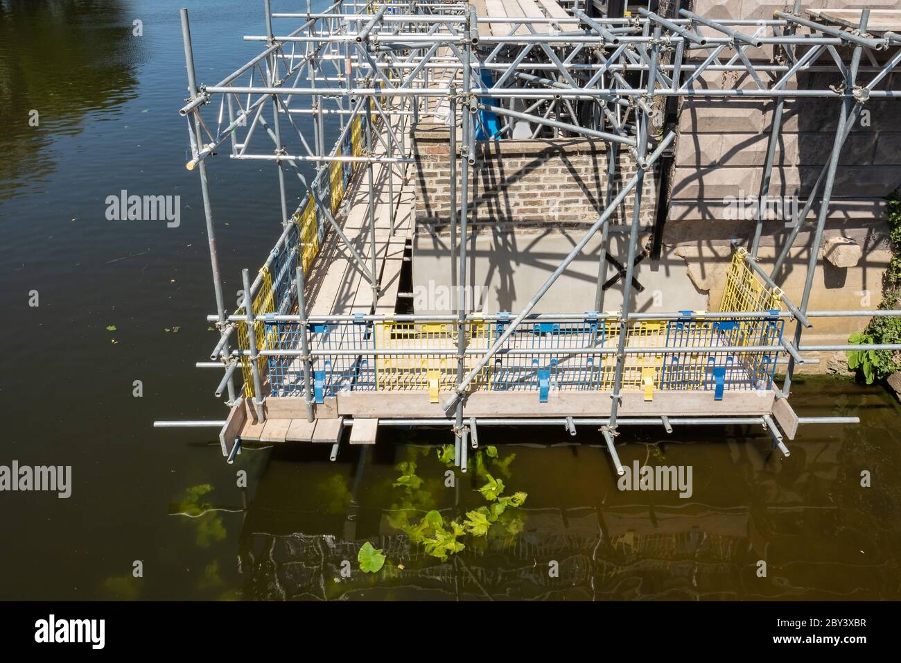 Installed scaffolding seen constructed on a riverside brick built ...