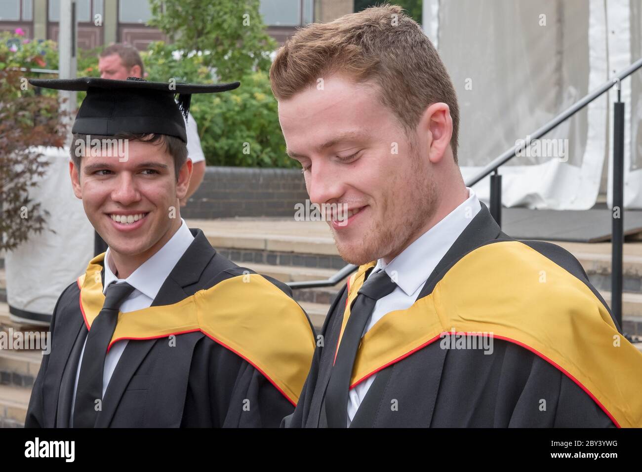 Pair of happy young men following their degree graduation ceremony. The ...