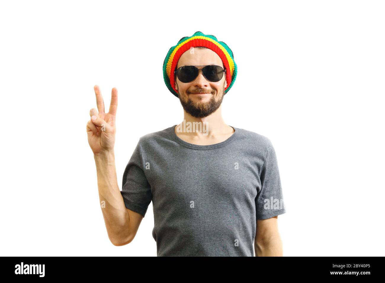 Young caucasian smiling man in rasta hat, sunglasses and grey t-shirt ...