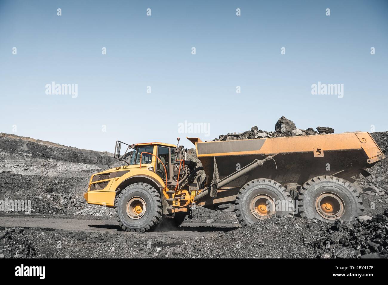Large quarry dump truck. Loading the rock in dumper. Loading coal into body truck. Production ...
