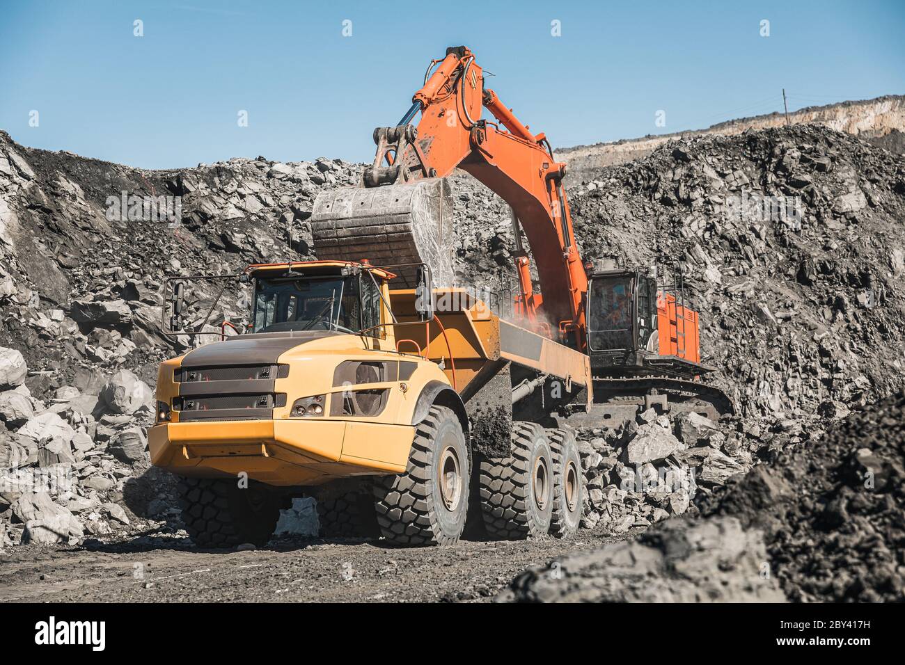Large quarry dump truck. Loading the rock in dumper. Loading coal into body truck. Production ...