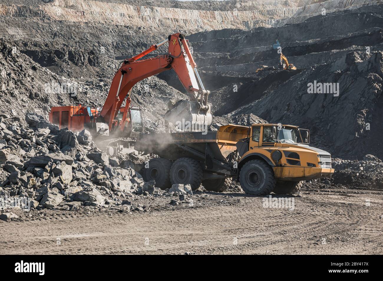 Large quarry dump truck. Loading the rock in dumper. Loading coal into body truck. Production ...