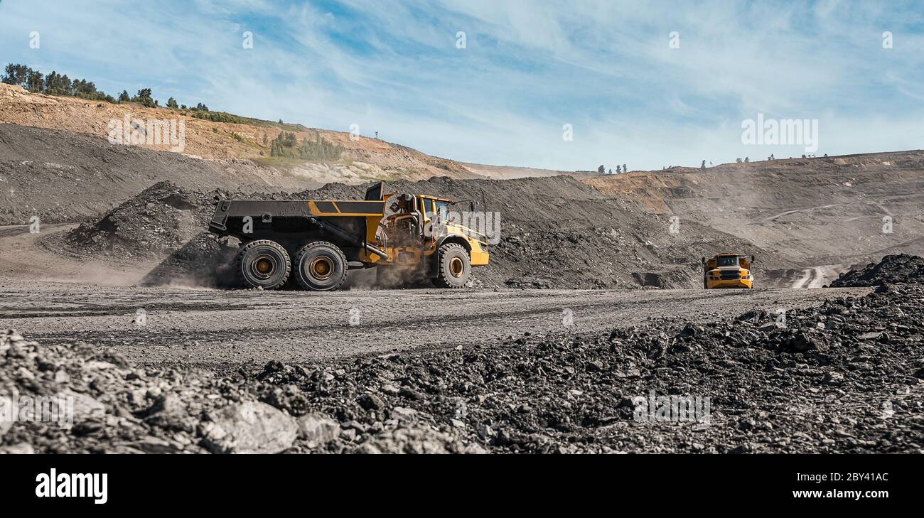 Large quarry dump truck. Loading the rock in dumper. Loading coal into body truck. Production ...