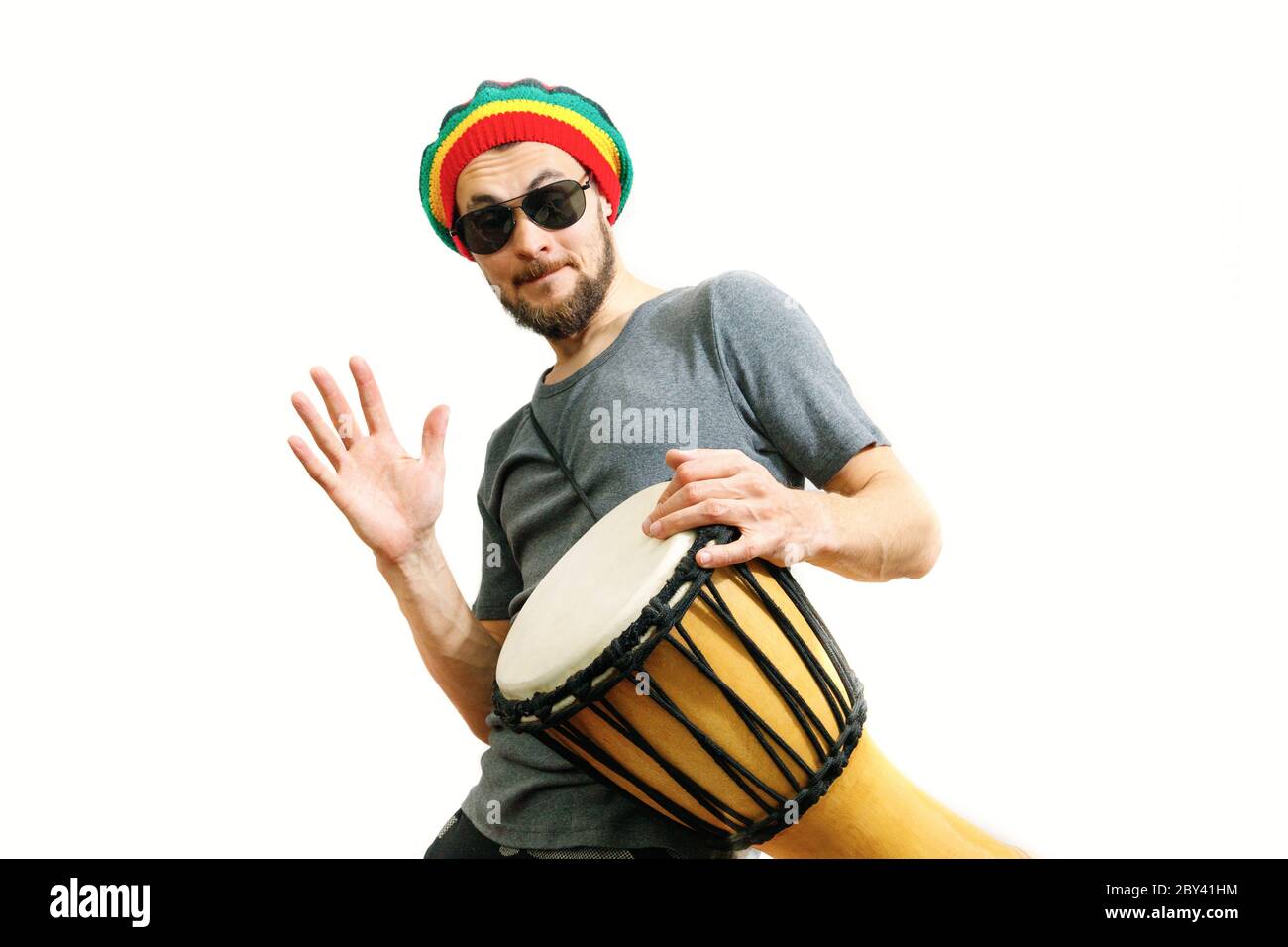 Young caucasian smiling man in rasta hat, sunglasses and grey t-shirt ...