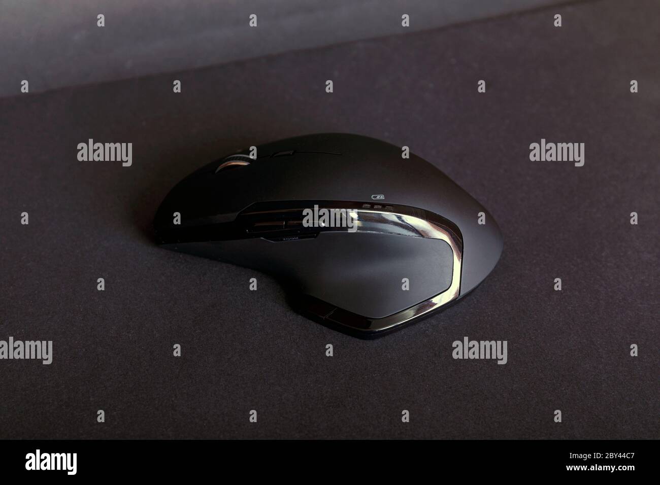 Matte black wireless computer gamer mouse on black paper textured ...