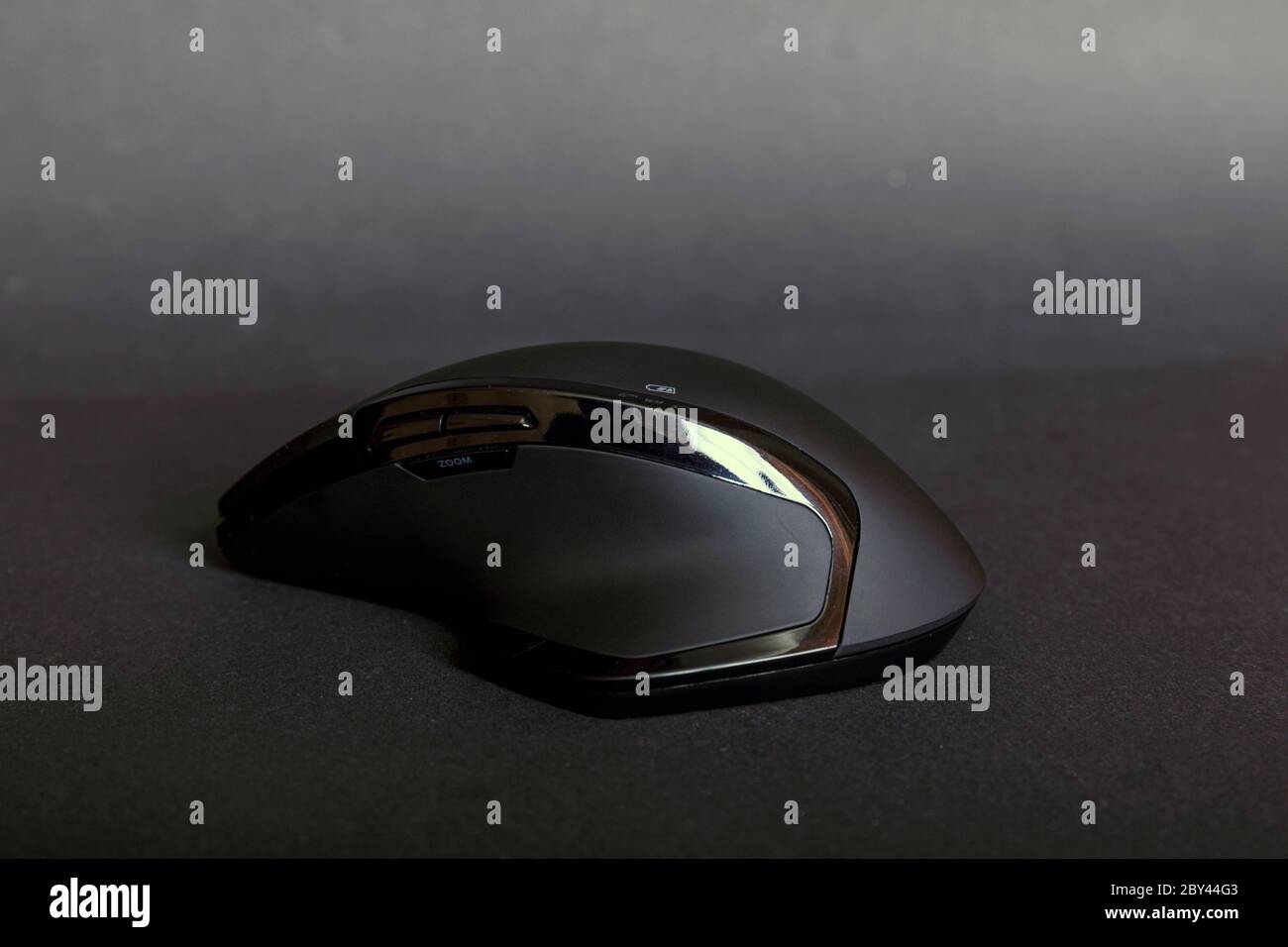 Matte black wireless computer gamer mouse on black paper textured ...