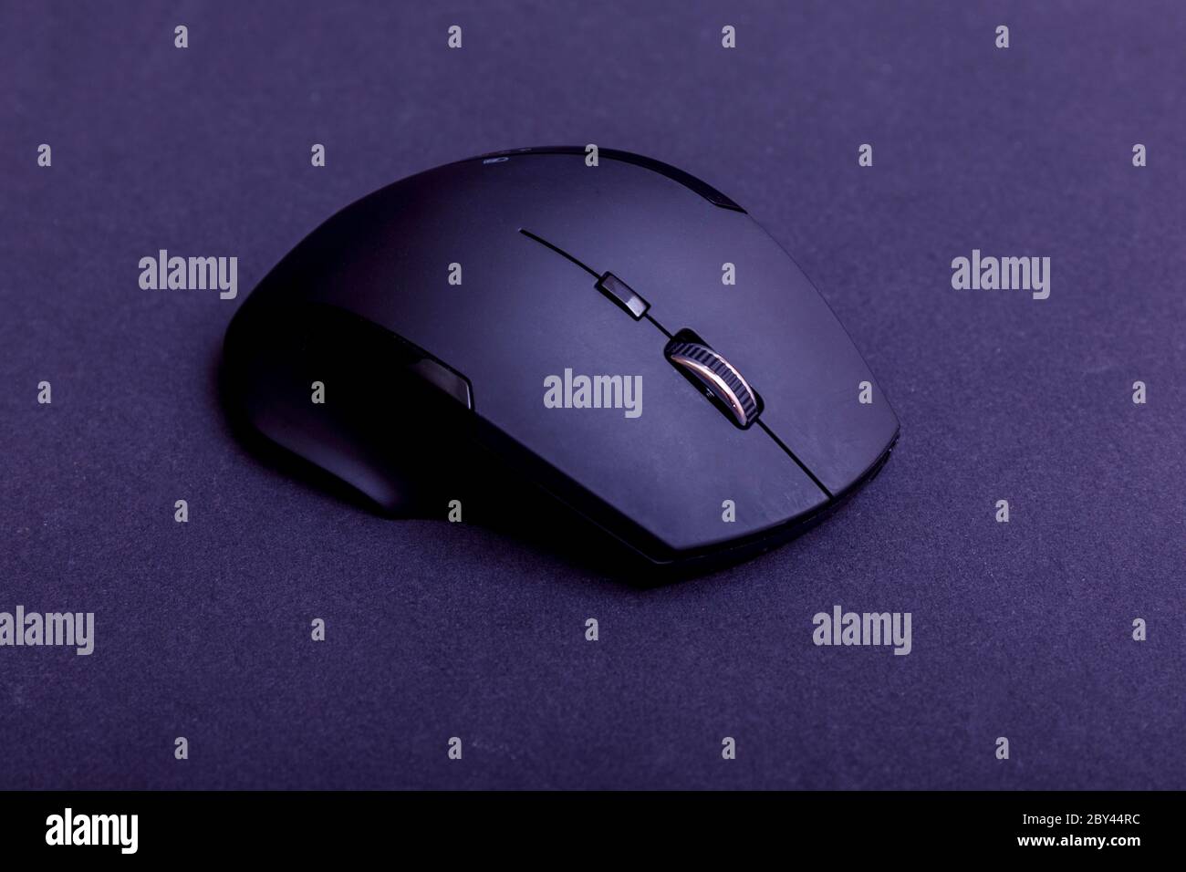 Matte black wireless computer gamer mouse on black paper textured ...