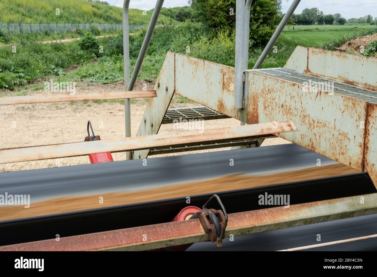 Fast moving conveyor belt seen moving quarry material from a nearby ...