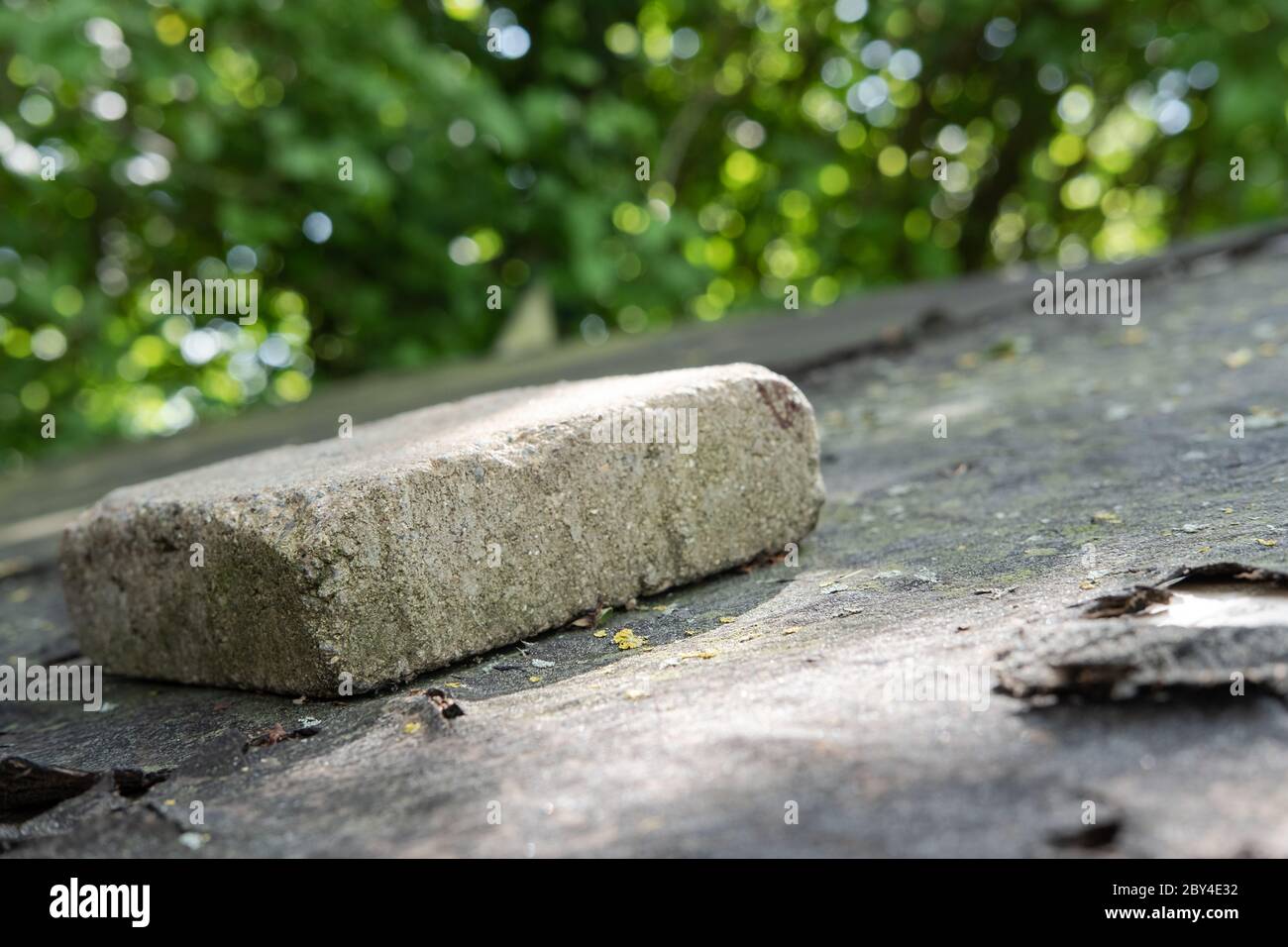 Heavy paving stone seen laid on an old shed roof following high wind ...