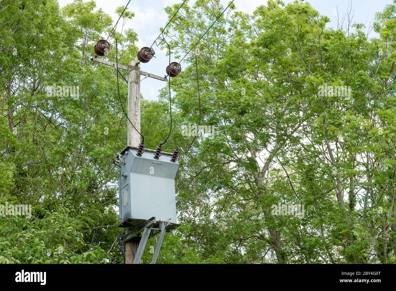 Electric power cables together with a large transformer seen attached ...