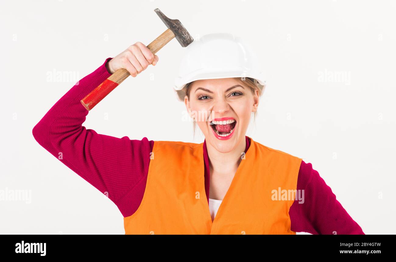 Girl in helmet, hard hat and builders uniform. Lady hammering on her ...