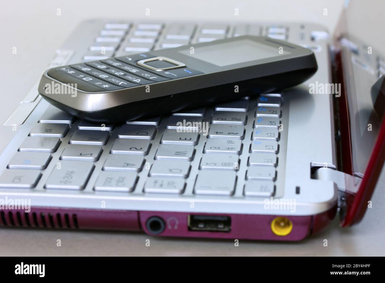 mobile phone over laptop keyboard Stock Photo - Alamy