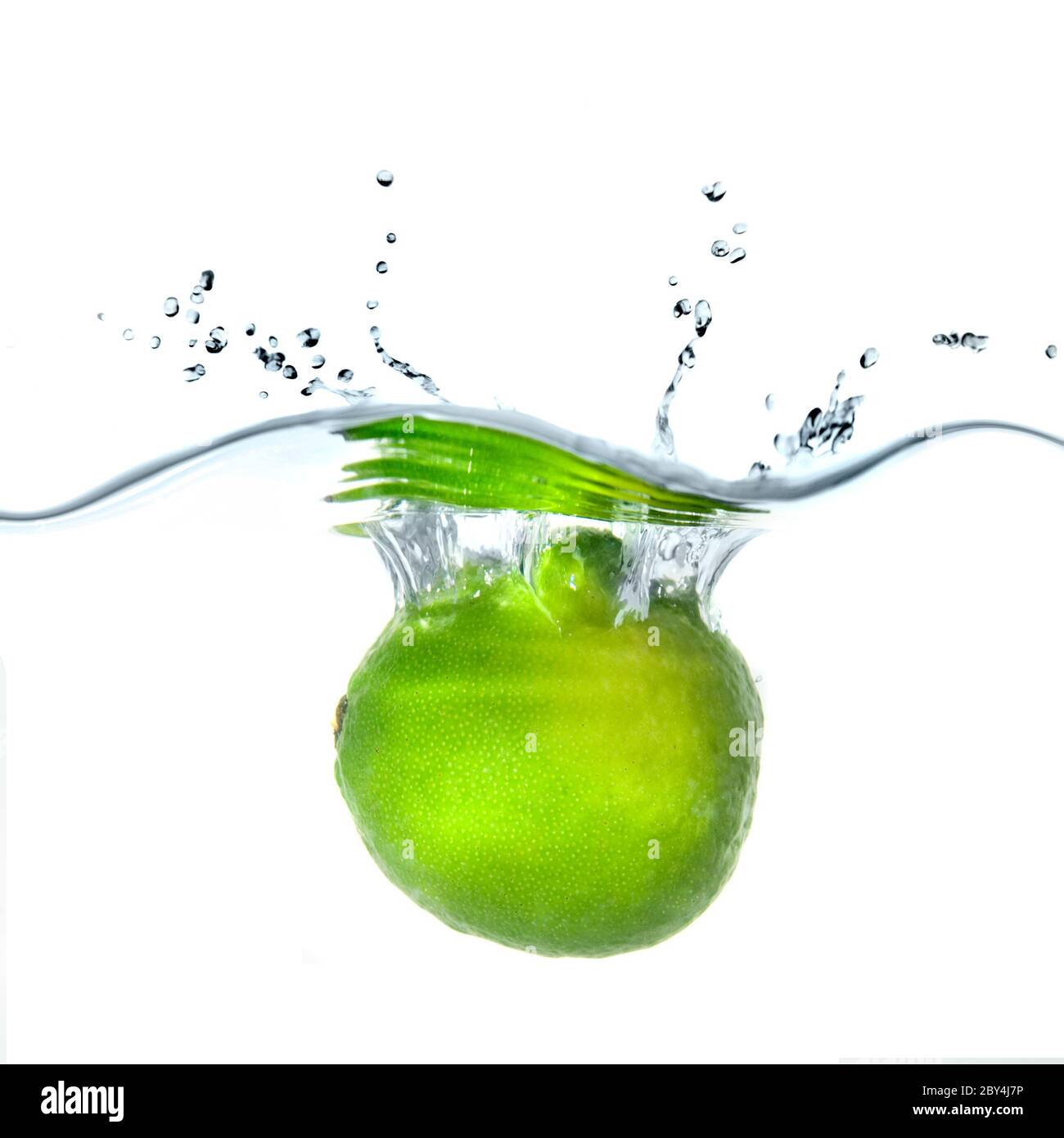 Fresh lime dropped into water with bubbles isolated on white Stock ...