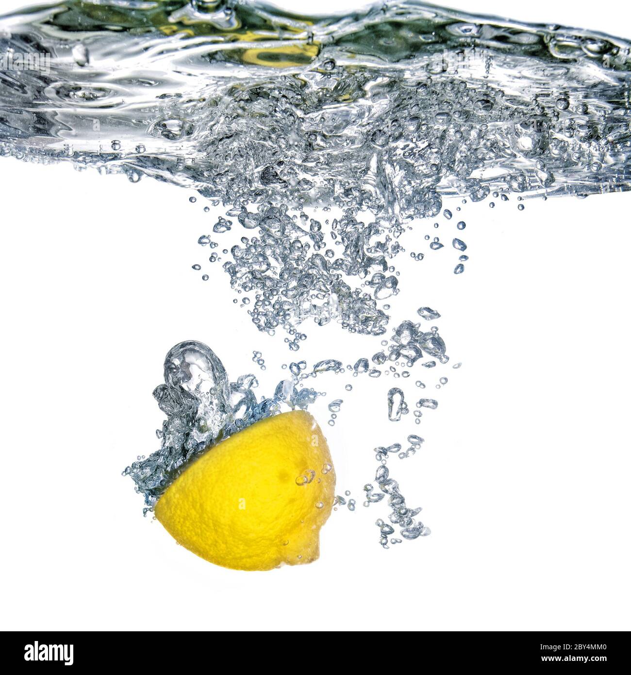 Fresh lemon dropped into water with bubbles isolated on white Stock ...
