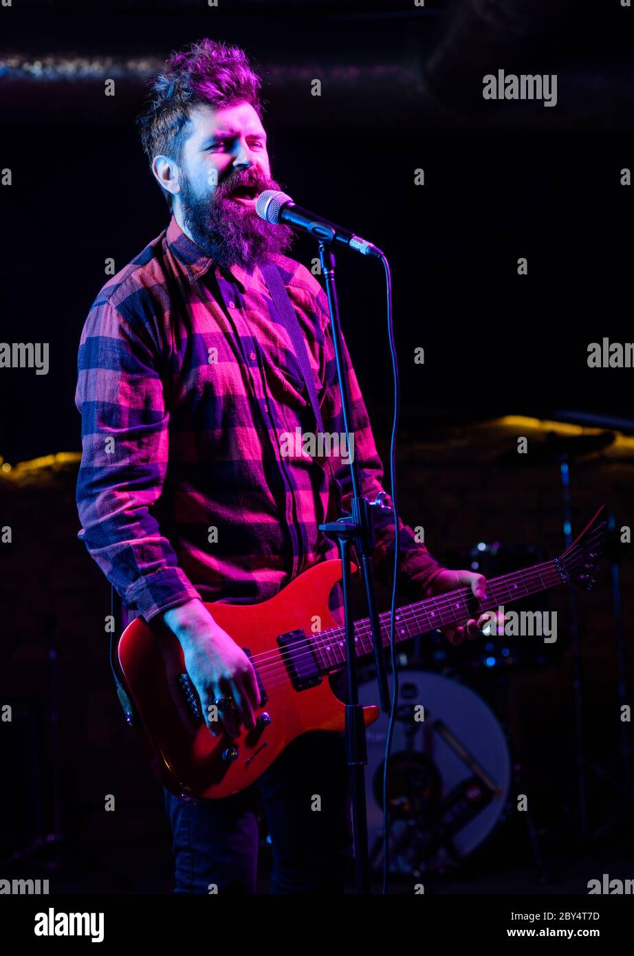 Frontman concept. Man with shouting face holds guitar, singing song ...