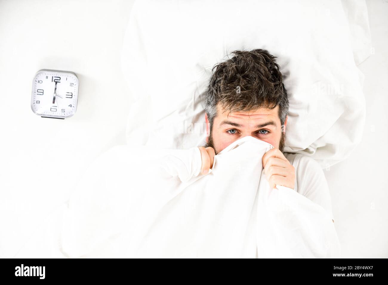 Morning and wake up concept. Man with surprised face lies on pillow ...