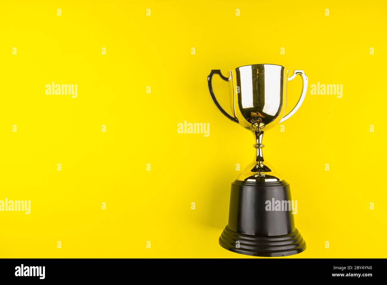 Golden trophy on yellow background.Concept championship Stock Photo - Alamy