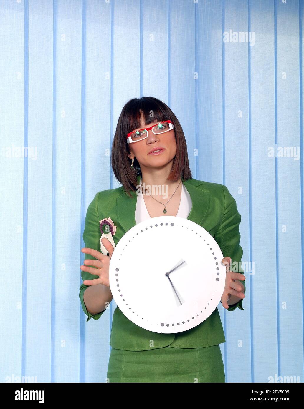 .a pretty business woman hiding behind a clock Stock Photo - Alamy