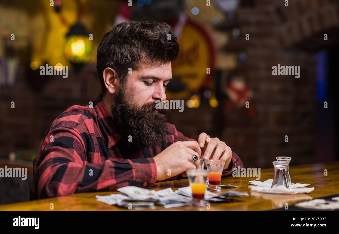 Depressed and sad man sit alone in bar or pub near bar counter ...