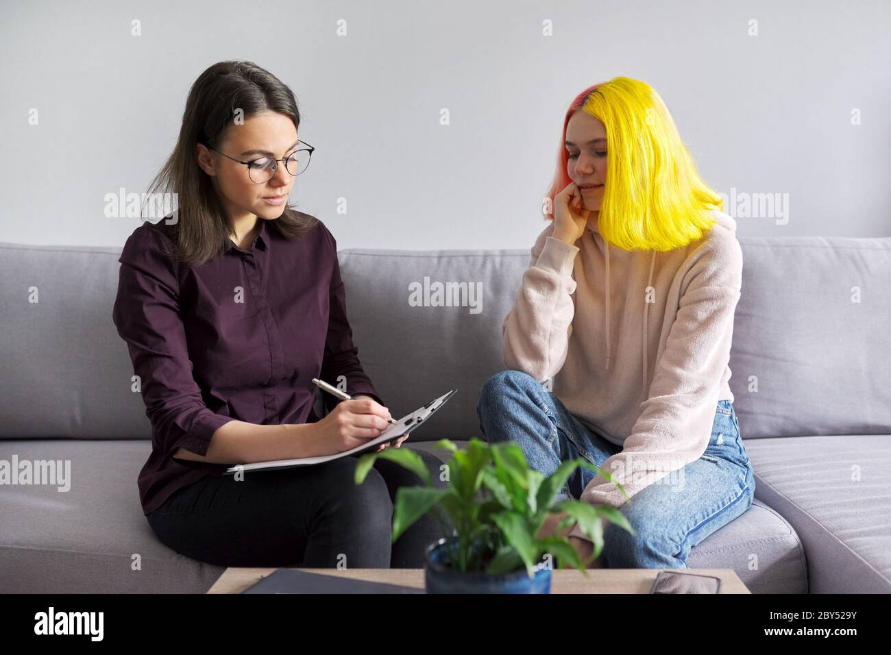 Teen girl giving interview to social worker. School psychologist ...