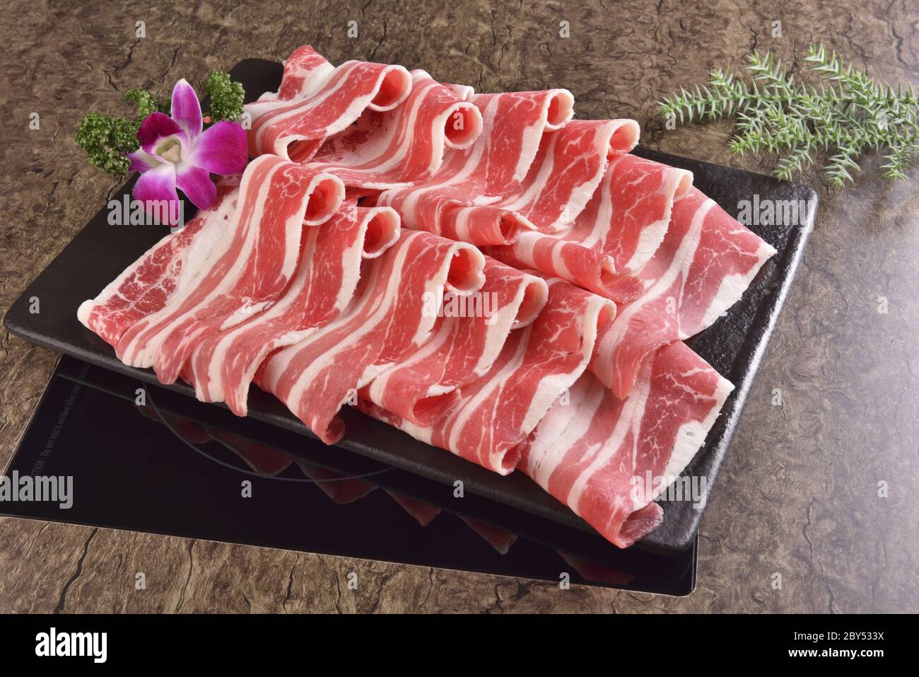 Slice of beef at the black plate material of hotpot Stock Photo - Alamy