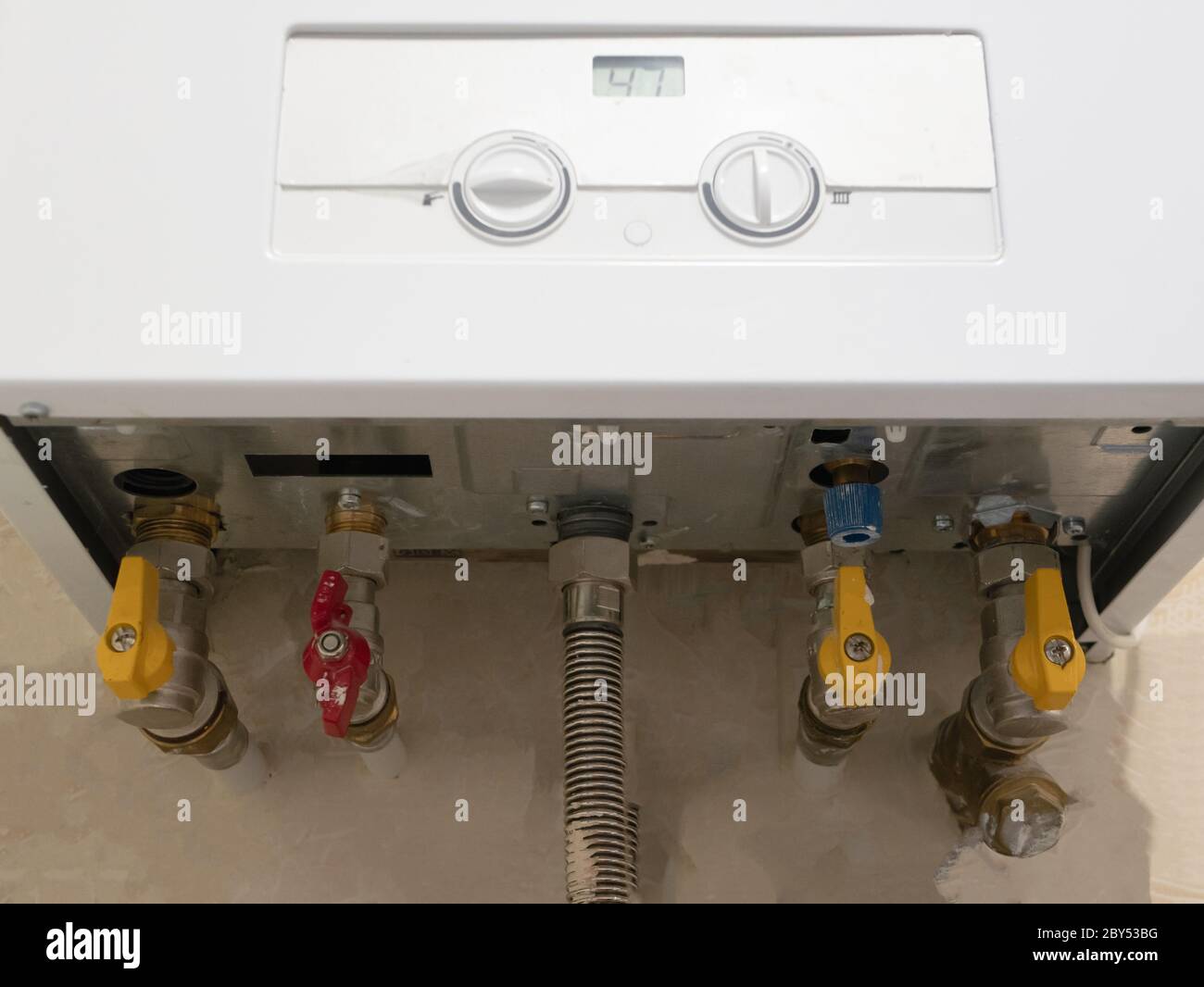 view from the bottom at gas fired boiler heater with lot of taps and ...