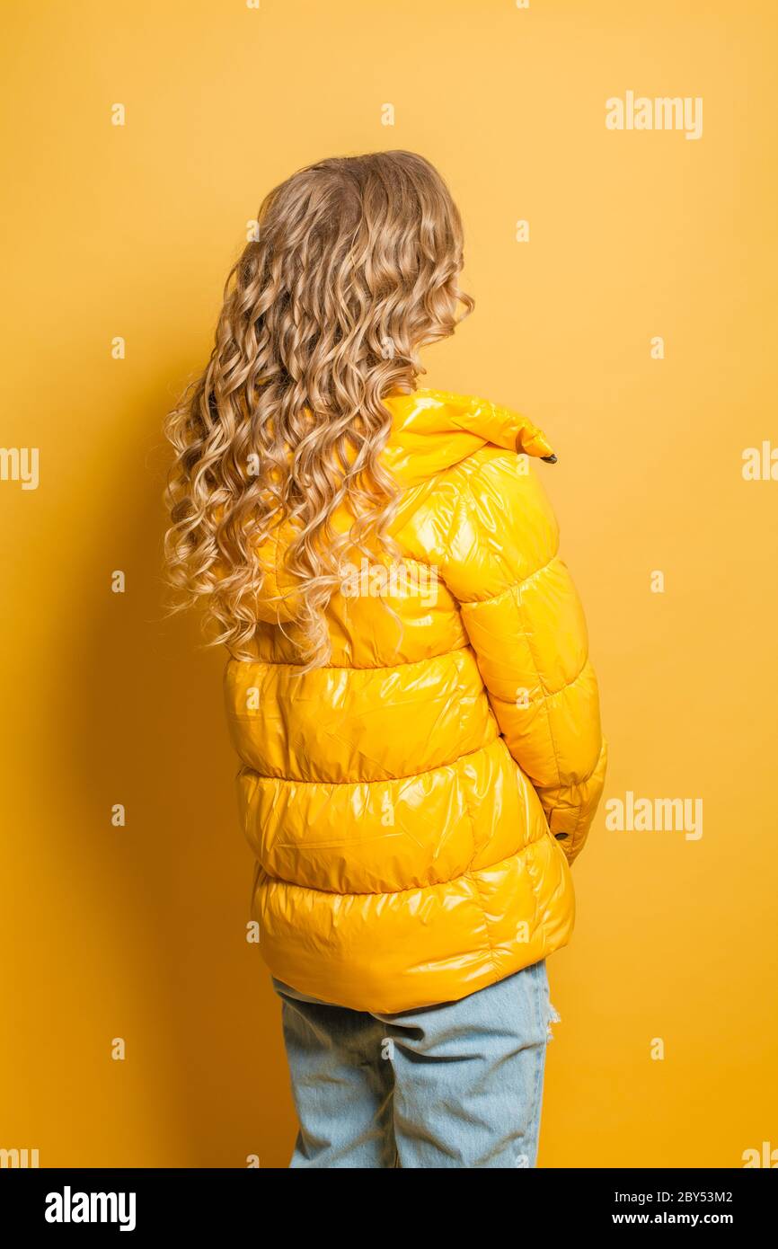 Fashion model woman in yellow winter jacket on bright background ...