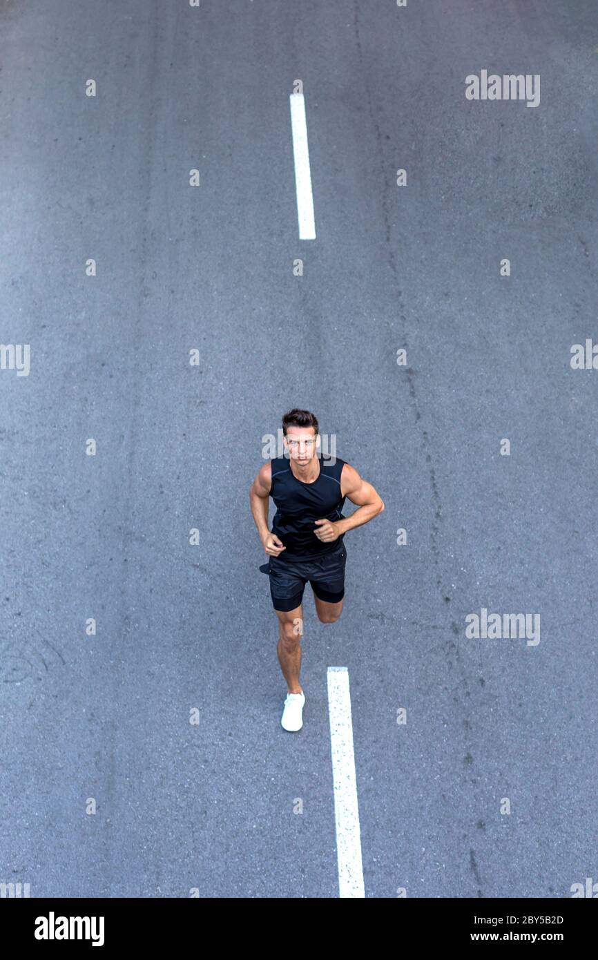 Above view athlete runner training at road in black sportswear Stock ...