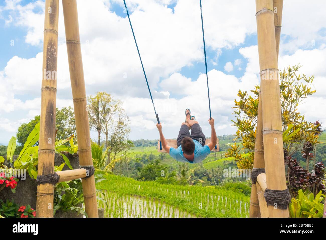 Happy female traveller swinging on wooden swing, enjoying summer ...