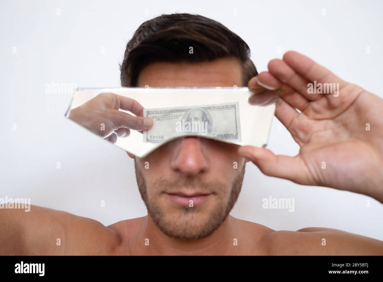guy holding a mirror which reflect a paper money Stock Photo - Alamy