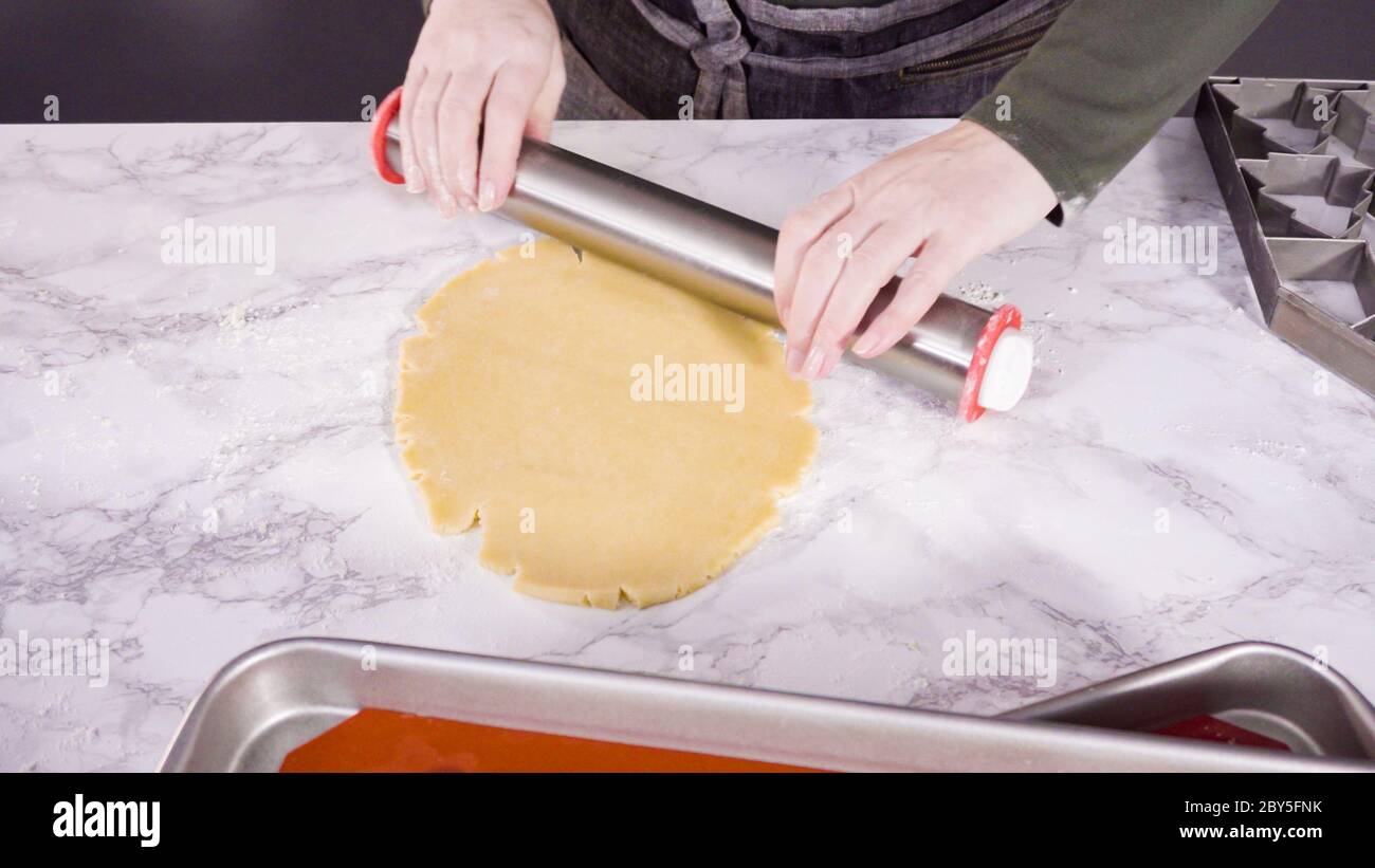 Step by step. Rolling out sugar cookie dough to bake Christmas cookies ...
