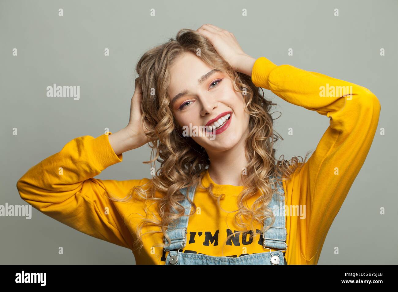 Happy model girl smiling on gray background Stock Photo - Alamy