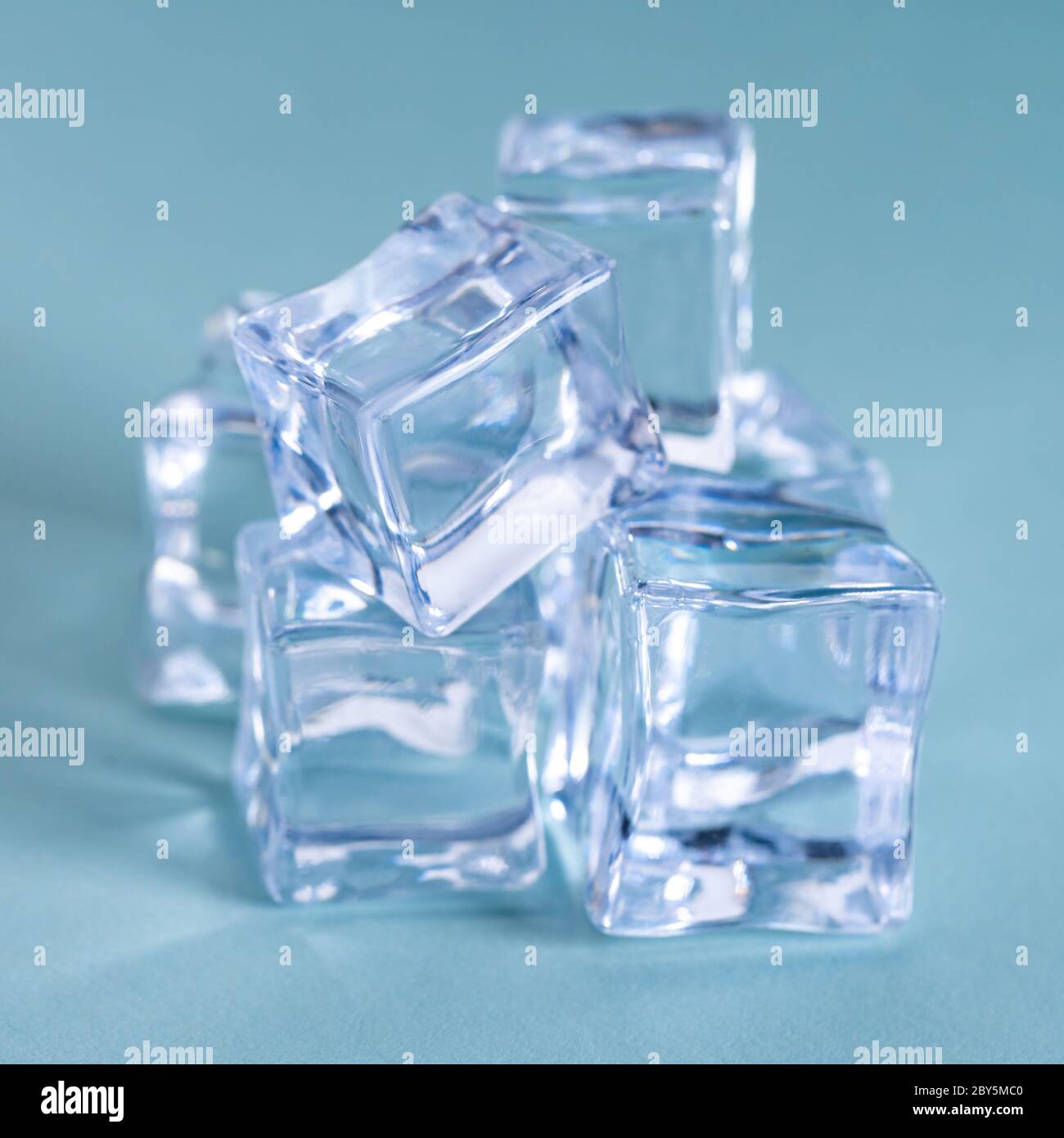Pile of plastic ice cubes isolated on blue background Stock Photo - Alamy